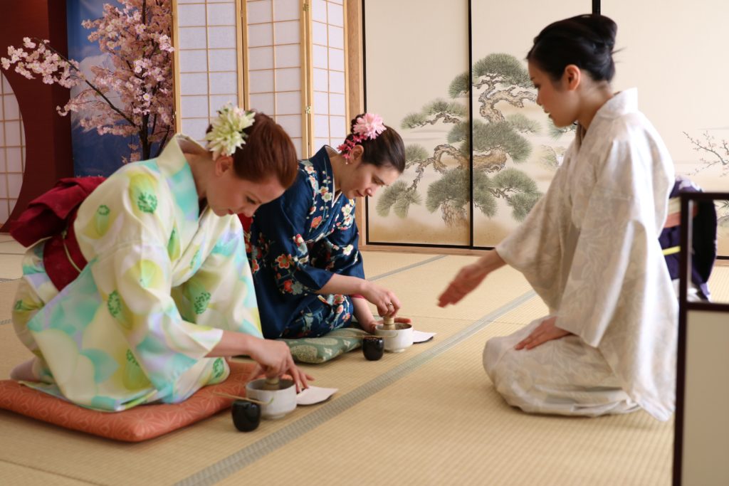 How does a guest of the Japanese tea ceremony show respect to the host?
